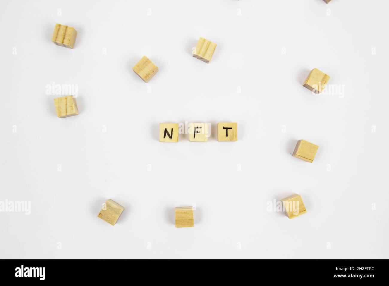 Word NFT (non fungible token) written on the wood cubes on white ...