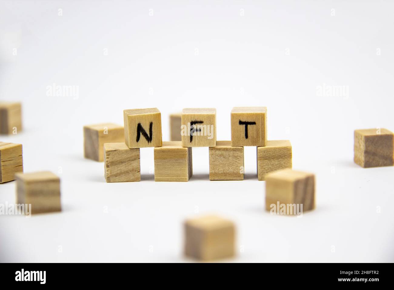 Word NFT (non fungible token) written on the wood cubes on white ...