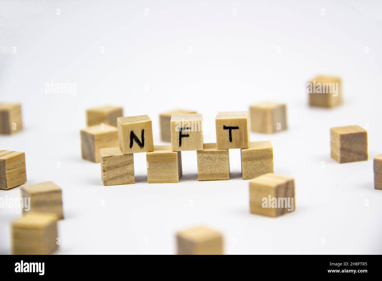 Word NFT (non fungible token) written on the wood cubes on white ...