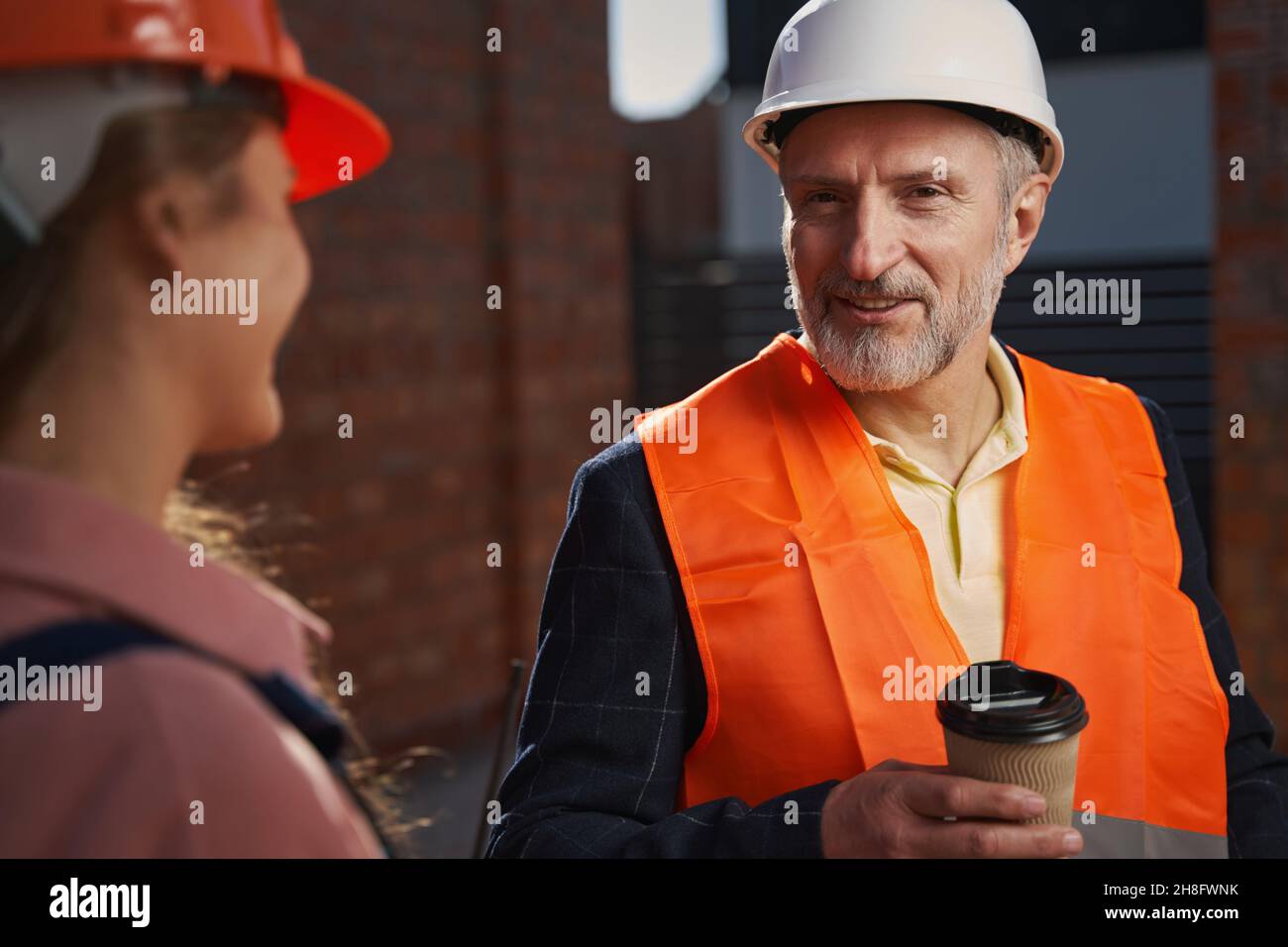 Friendly chit-chat between construction site workers outdoor Stock ...