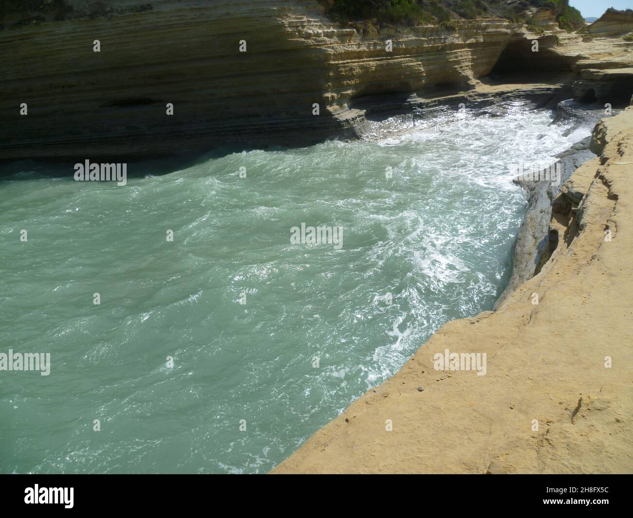 Mesmerizing view of lake water flowing through the cliffs of Corfu ...
