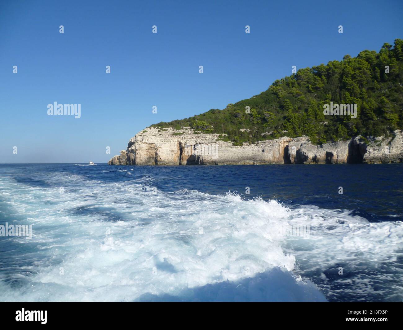Beautiful view of cliffs with greenery on top over the water surface ...