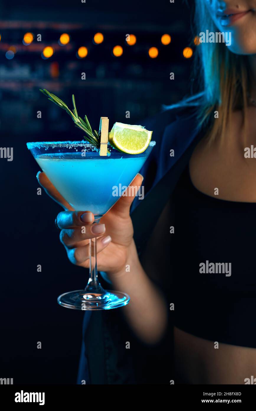 Young woman in a bar or club having fun - in the background her bar ...