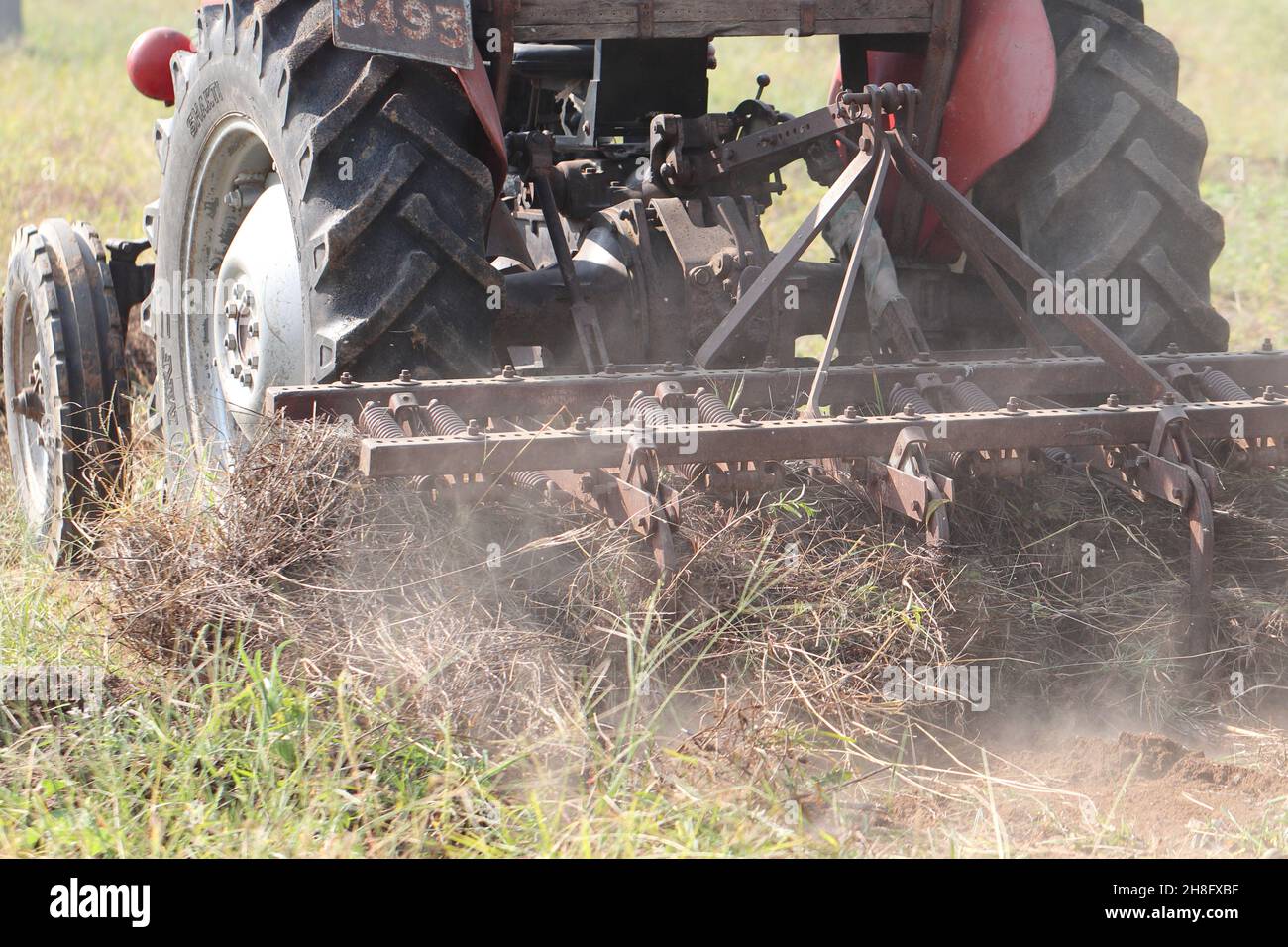 Tractor plowing the field with the help of a plow Stock Photo - Alamy