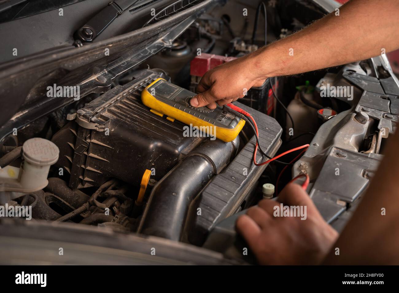 Auto mechanic measures voltage with multimeter Stock Photo - Alamy