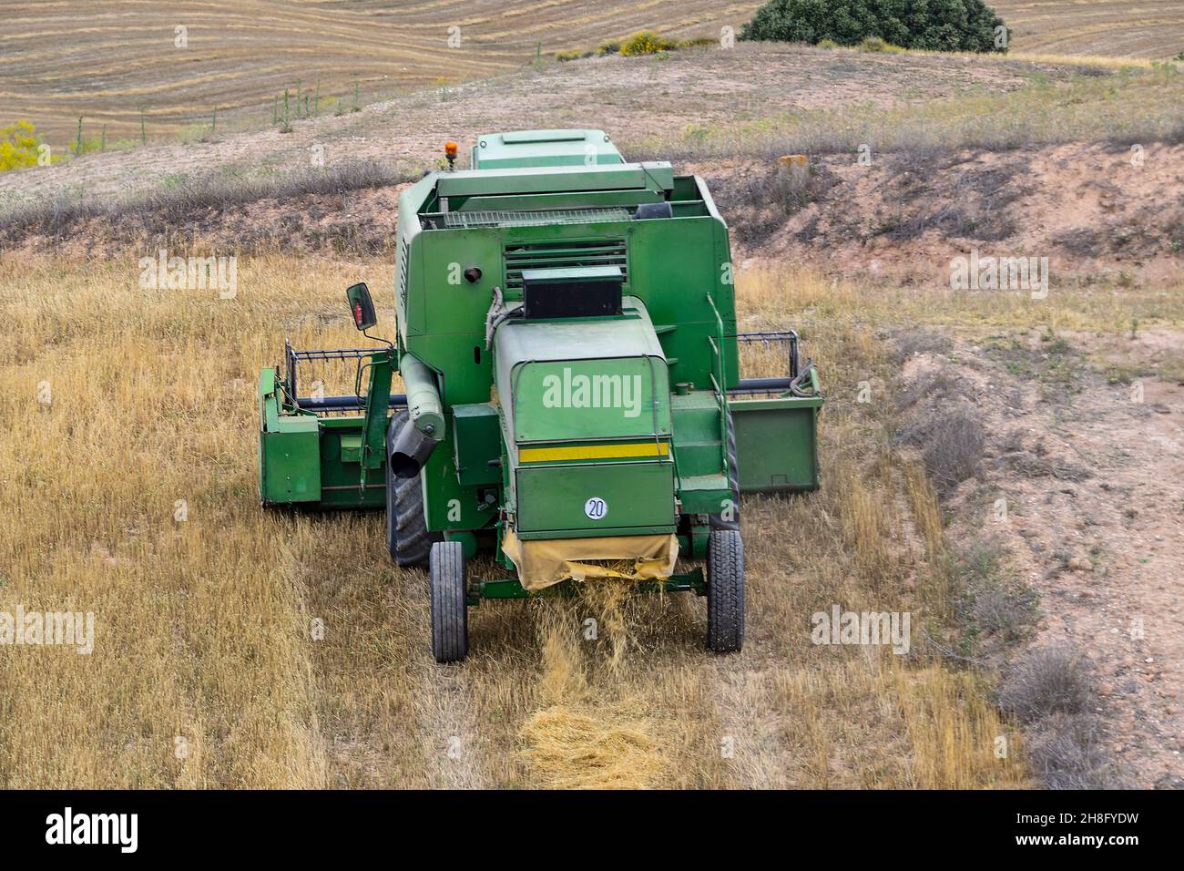 Photo of combine harvester that is harvesting wheat with dust straw in ...