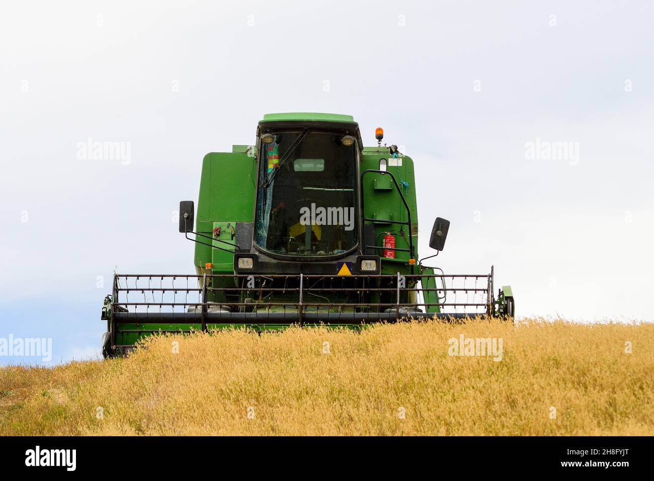 Photo of combine harvester that is harvesting wheat with dust straw in ...