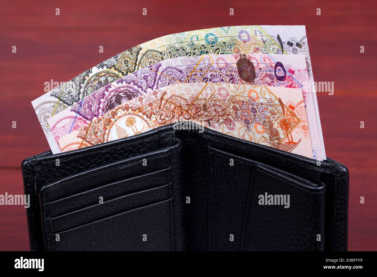 Qatari money - Riyal in the black wallet Stock Photo - Alamy