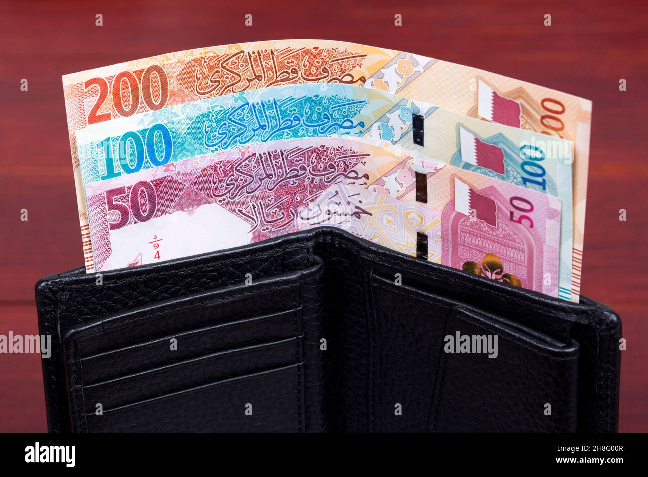 Qatari money in the black wallet - new series of banknotes Stock Photo ...