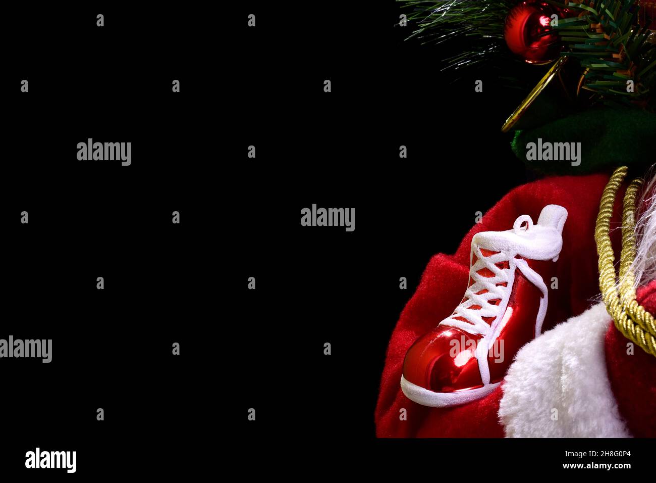 Photograph of a red Christmas shoe on a Santa Claus arm.The photo is ...