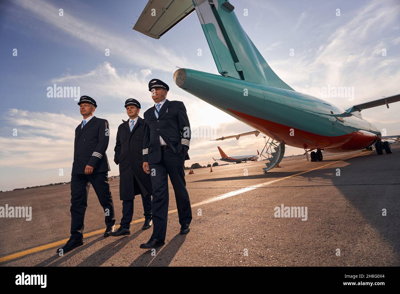 Three plane captains making a step forward from airplane Stock Photo ...