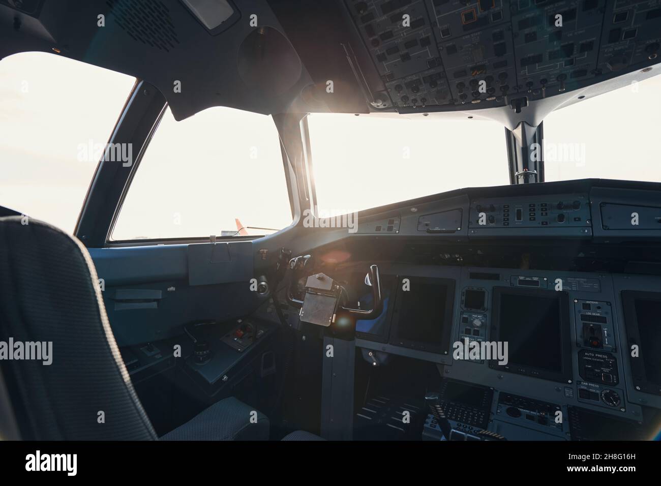Empty airplane cockpit with sun shining through window Stock Photo - Alamy