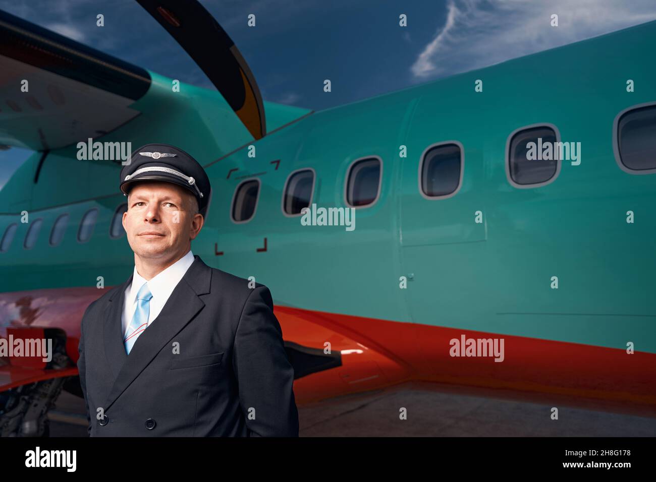 Man pilot posing for photo outside before airplane Stock Photo - Alamy