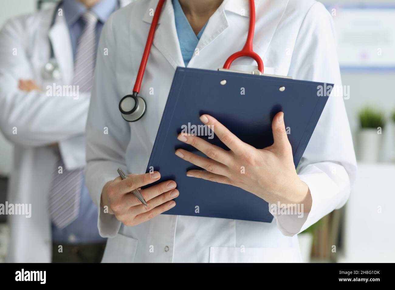 Medical coworkers in uniform posing in clinic with prescription paper ...