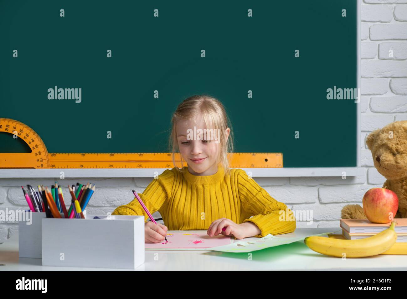Cute little child studying in classroom at elementary school. Education ...