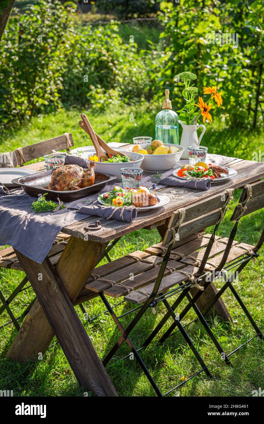 Dinner with chicken served in garden. Dinner in garden. Homemade dinner ...