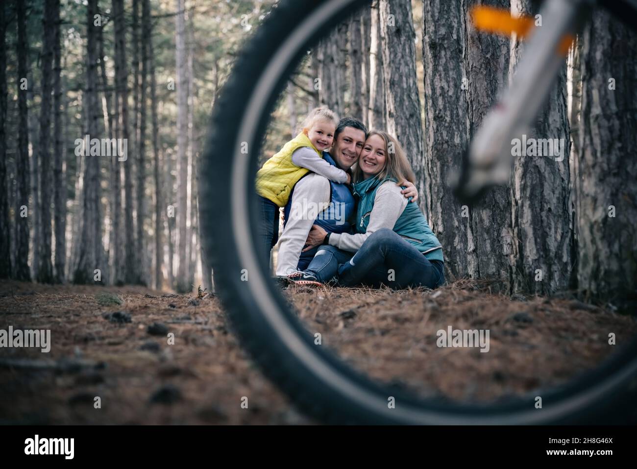 A family rides bicycles through the forest. A creative perspective ...