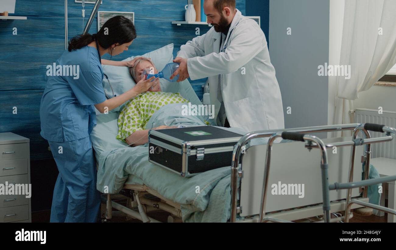 Doctor and nurse using oxygen tube for resuscitation with heart rate ...
