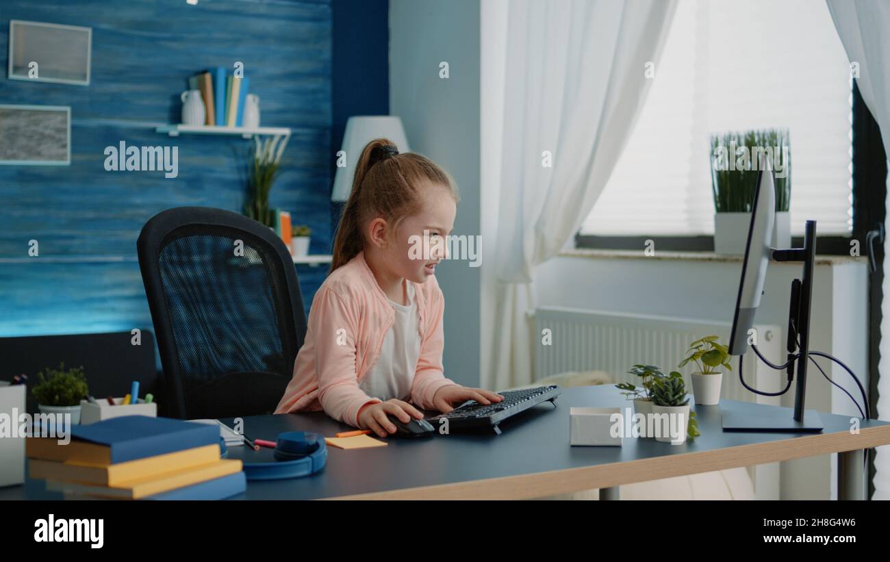 Frustrated child using computer and keyboard for homework at home ...