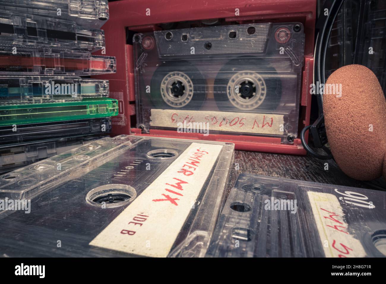 One cassette in red audio player with headphones. Player and spinning ...