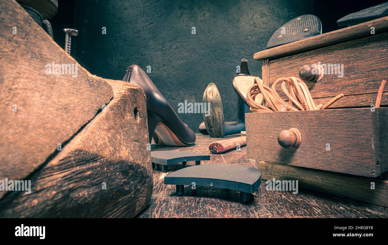 Old cobbler workplace with with tools, anvil, shoes and rule. Old ...