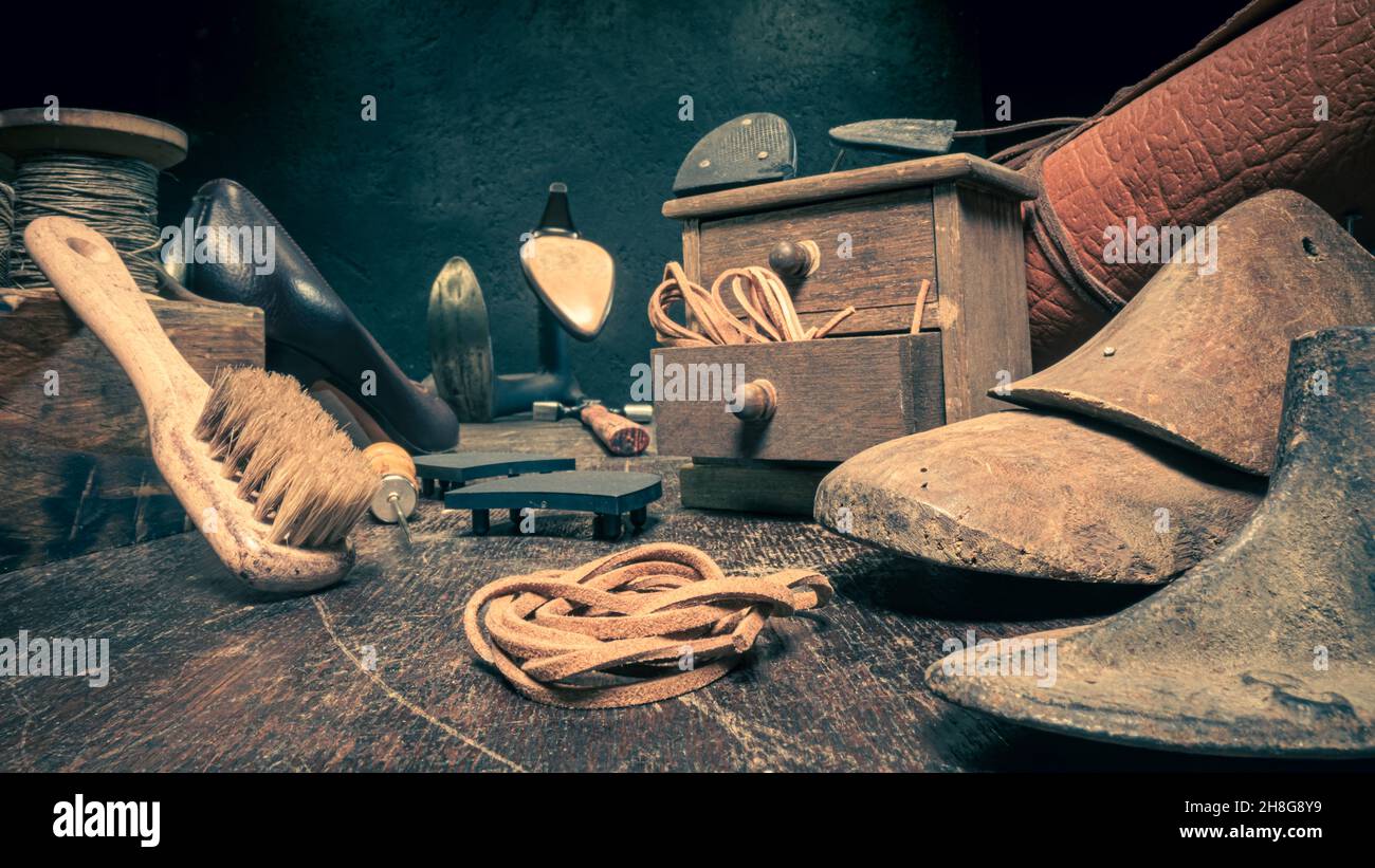 Vintage cobbler workplace with with tools, anvil, shoes and rule ...
