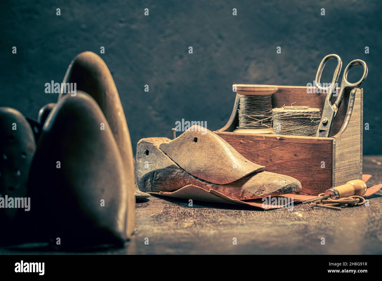 Traditional cobbler workplace with with tools, anvil, shoes and rule ...