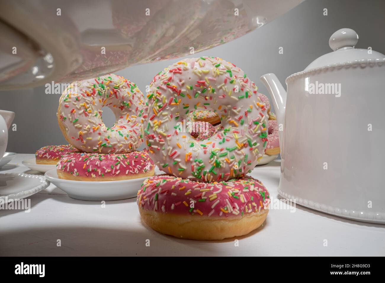 Multi colored donuts with sprinkles and icing. Table full of donuts ...