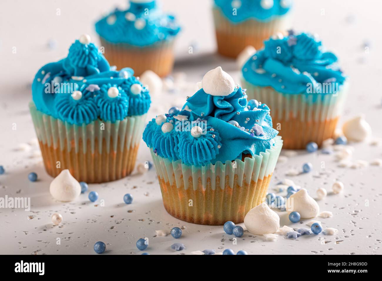 Tasty cupcakes with blue whipped cream ready to eat. Perfect blue ...