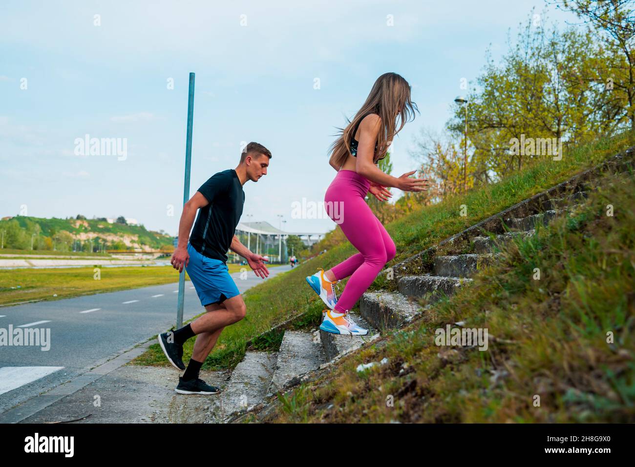 Attractive young couple in sporty outfits running together and having ...