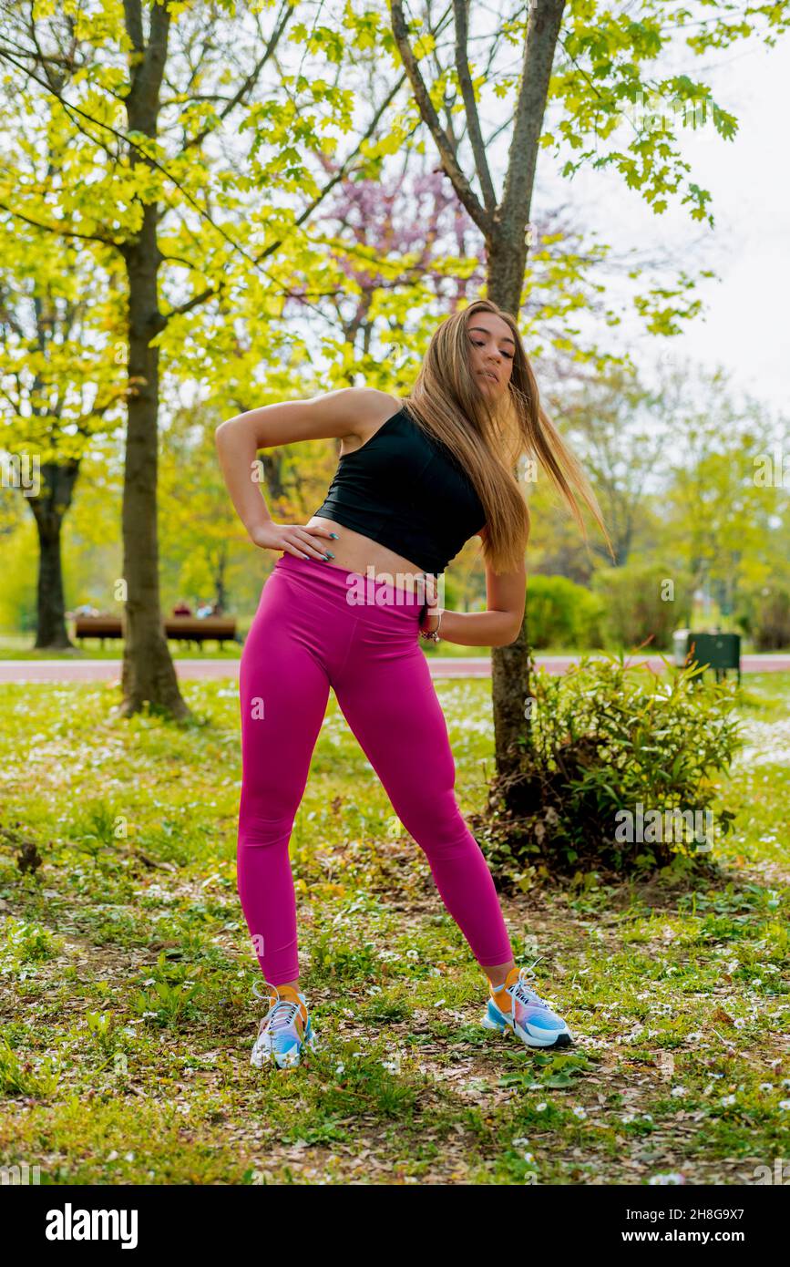 Female runner with perfect figure stretch body muscles while exercise ...