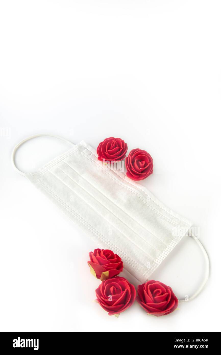 Red roses and a protective medical face mask isolated on white ...