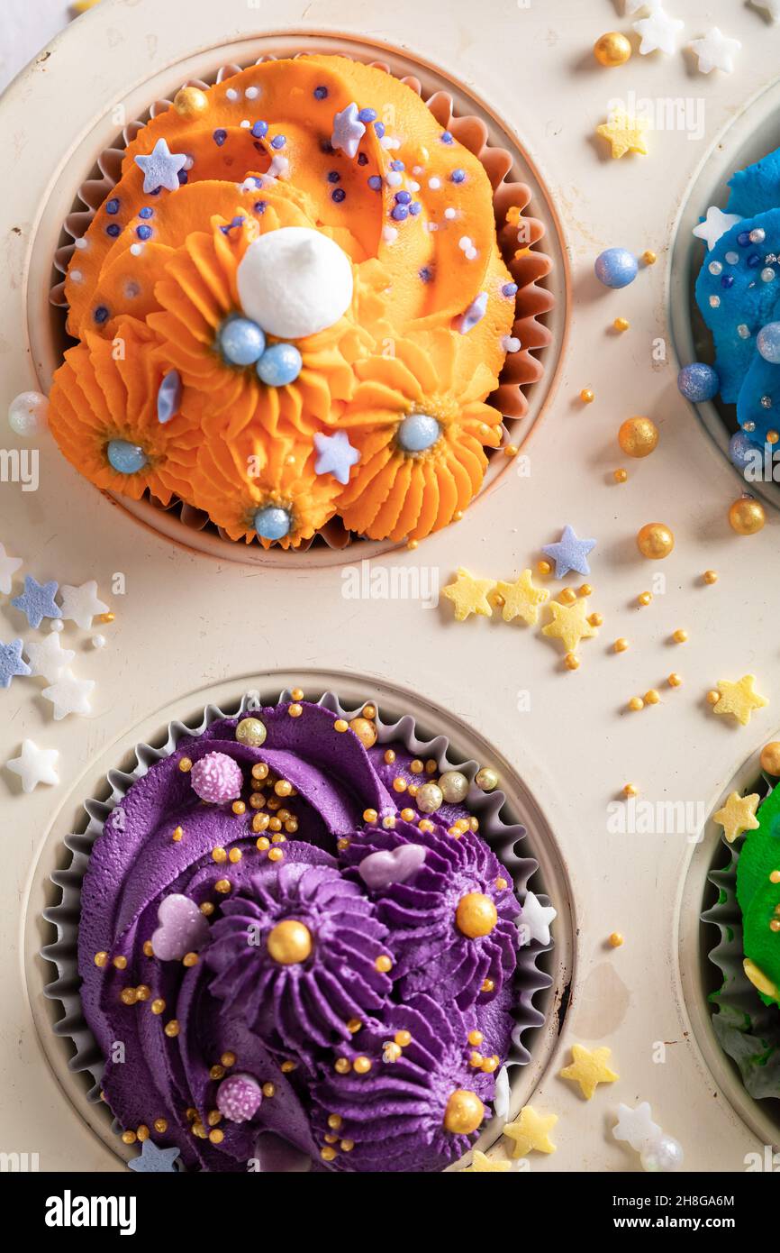 Unique multicolored cupcakes with sprinkles and colored cream. Colored cupcakes with sprinkles ...