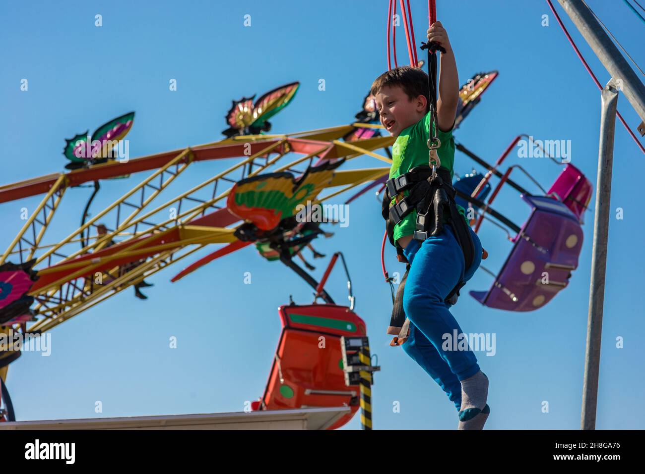 Beautiful boy having fun on the amusement attractions at the local ...