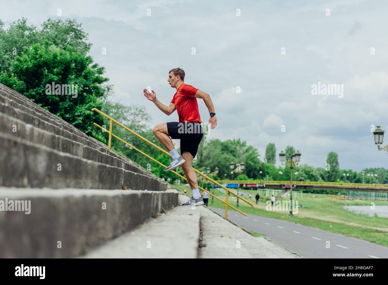 Fit male athlete performing stairs workout, running up climbing stairs ...