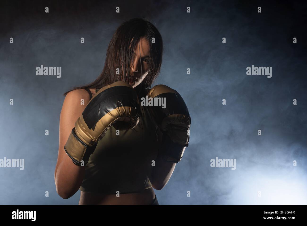 Closeup portrait of a female boxer posing with boxing gloves and ...