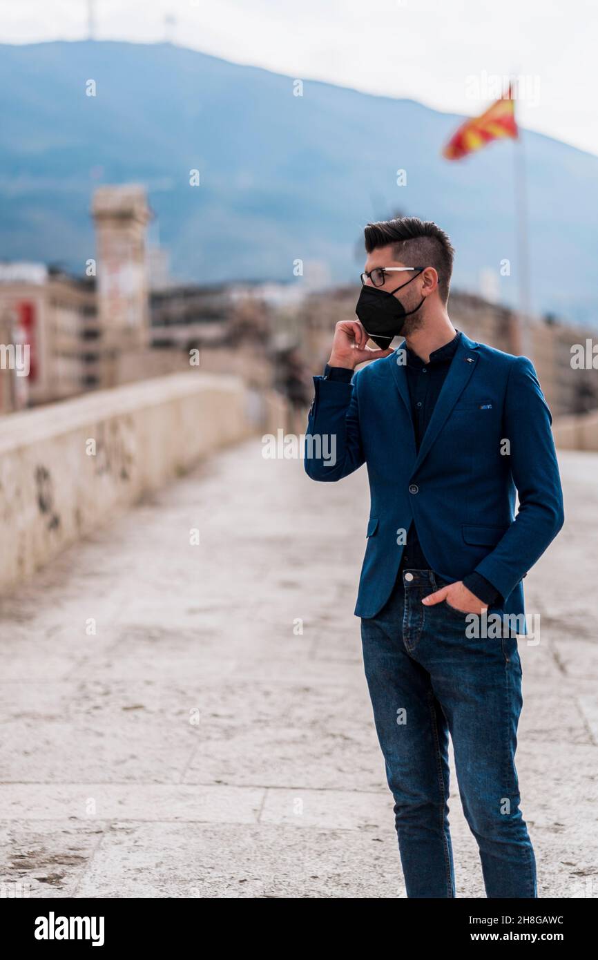 Young businessman walking outdoors while talking on cellphone Stock ...