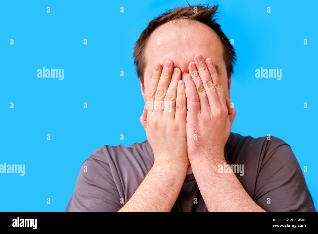Portrait of a crying adult man with a disheveled appearance, blue ...