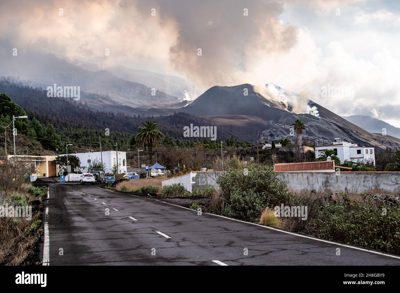 Small houses located in countryside against active volcano in daytime ...