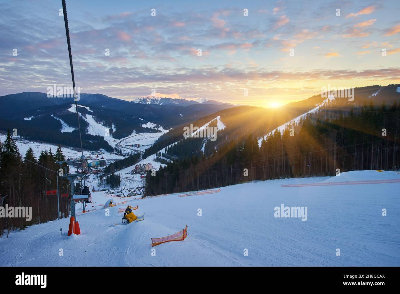Ski resort in beautiful sunset light. View from the top: ski tracks ...