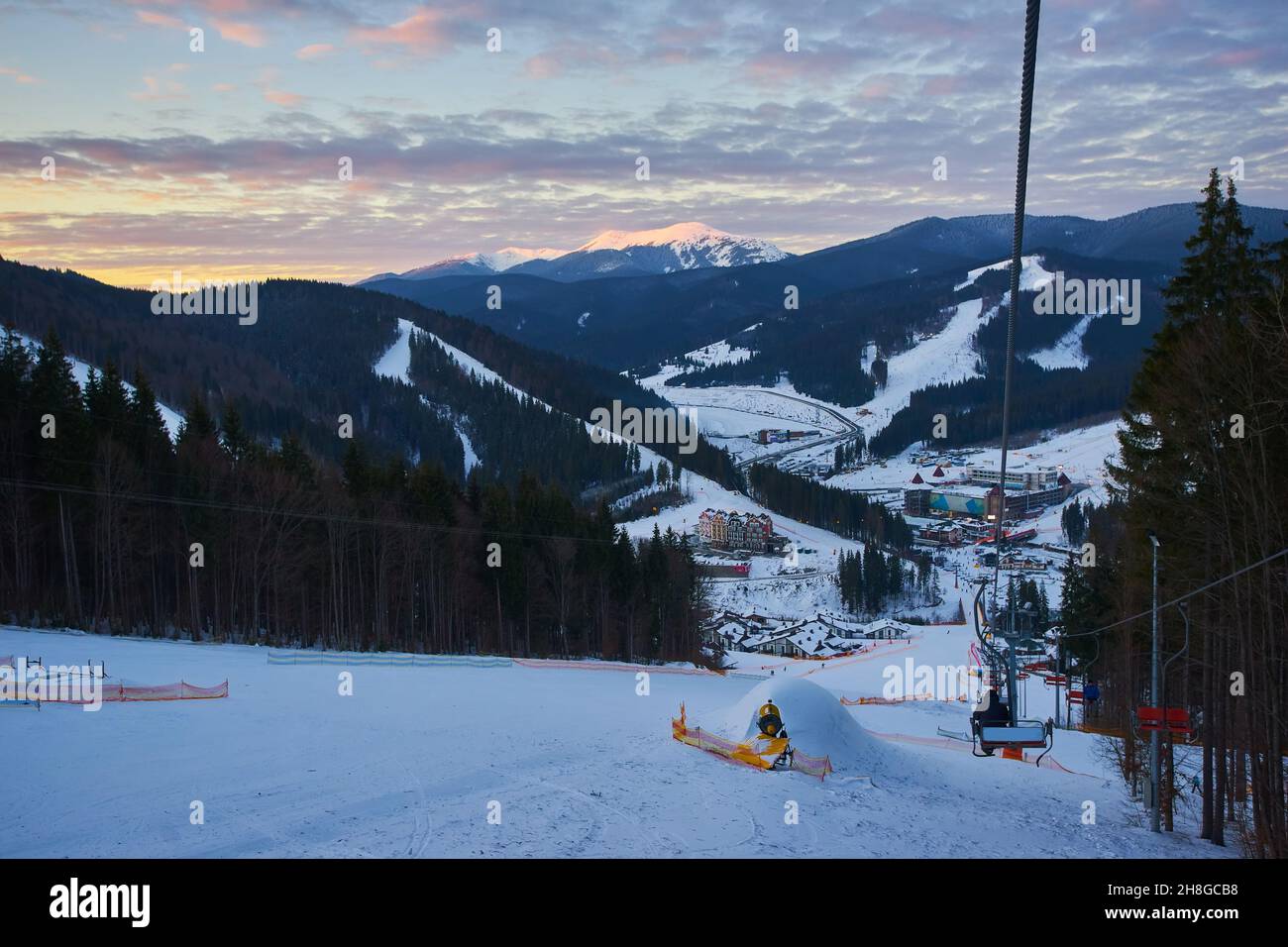Ski resort in beautiful sunset light. View from the top: ski tracks ...