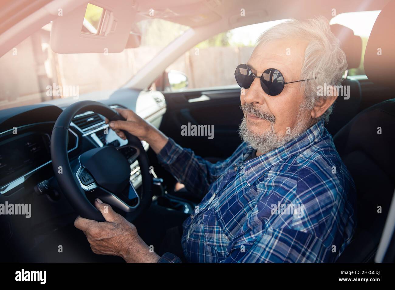 Old man pensioner in round sunglasses driving car Stock Photo - Alamy
