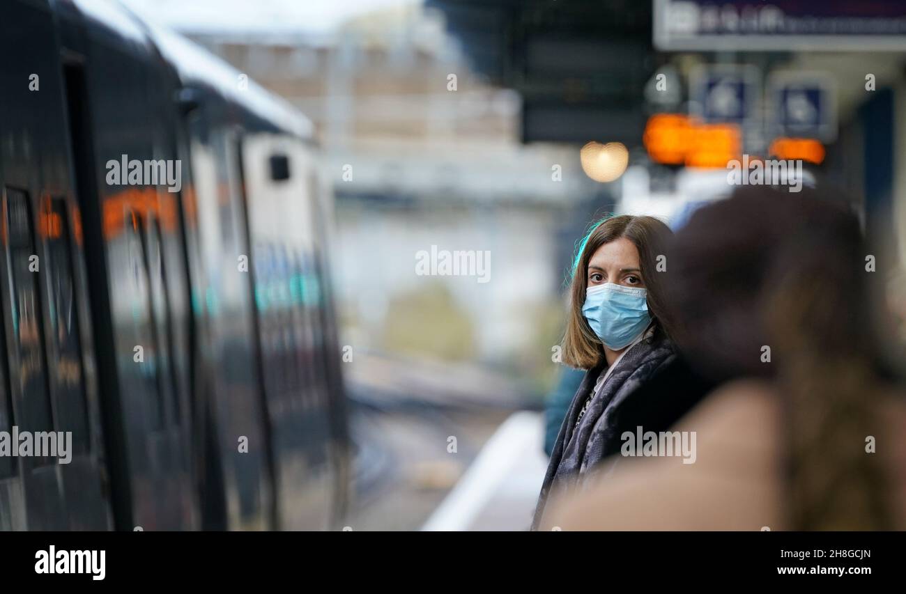 A lady waits to board a train at Ashford Railway Station in Kent, as ...