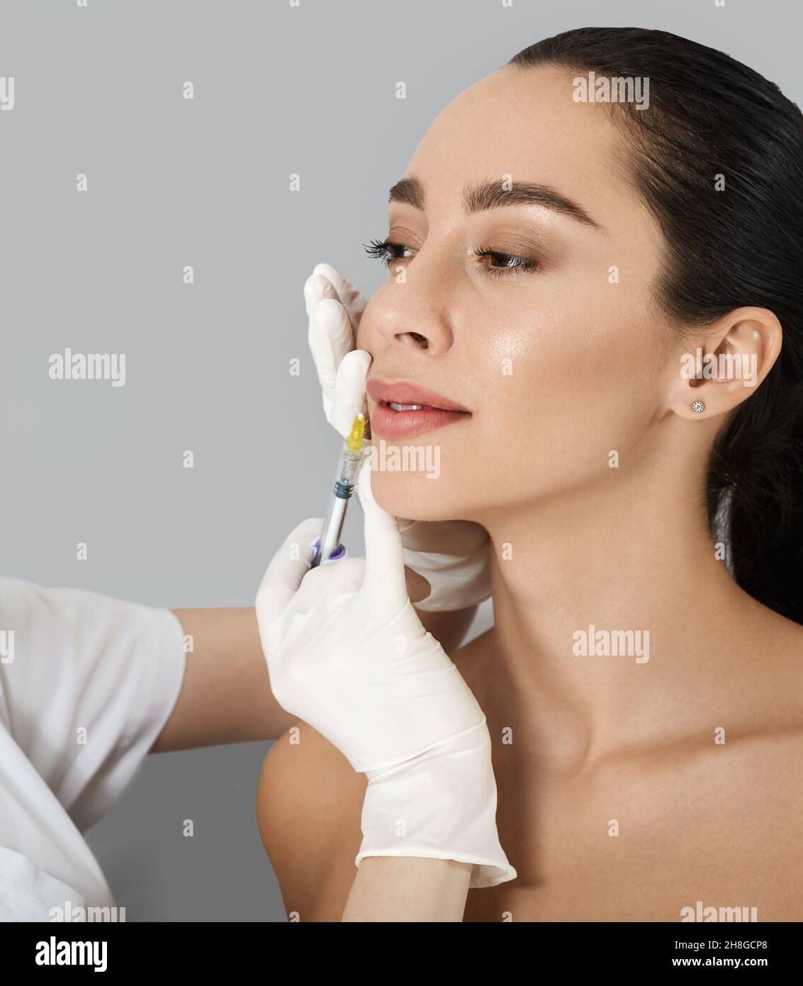 Beautician doing filler injection in female lips for woman's lip ...