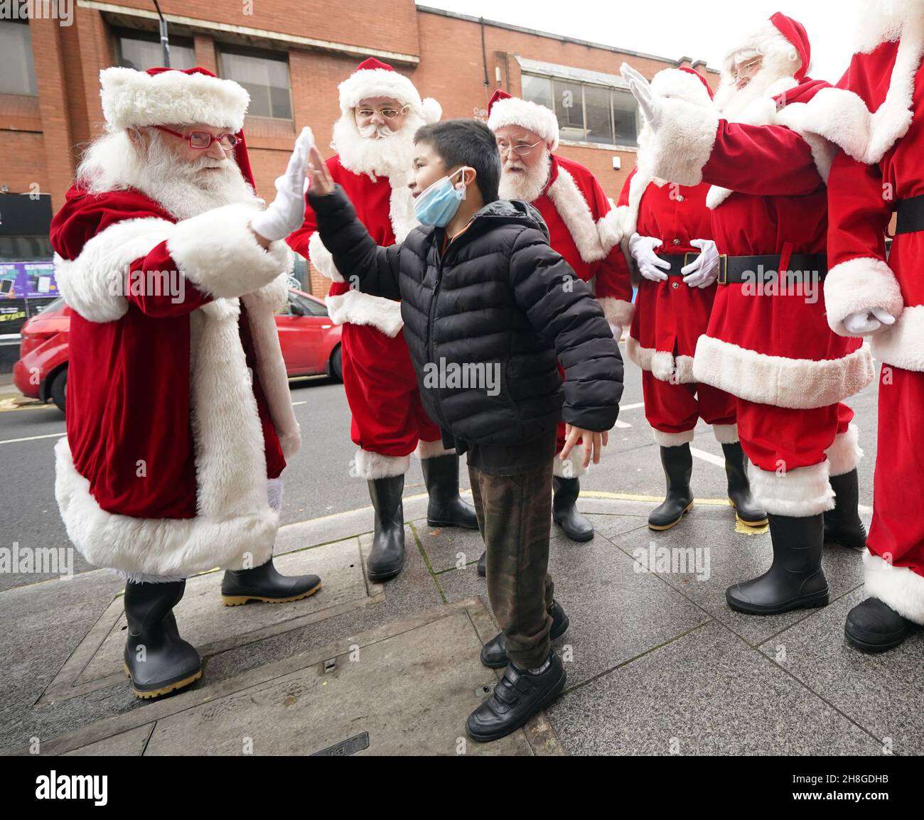 Santa students high-five a passing boy as the annual Santa school ...