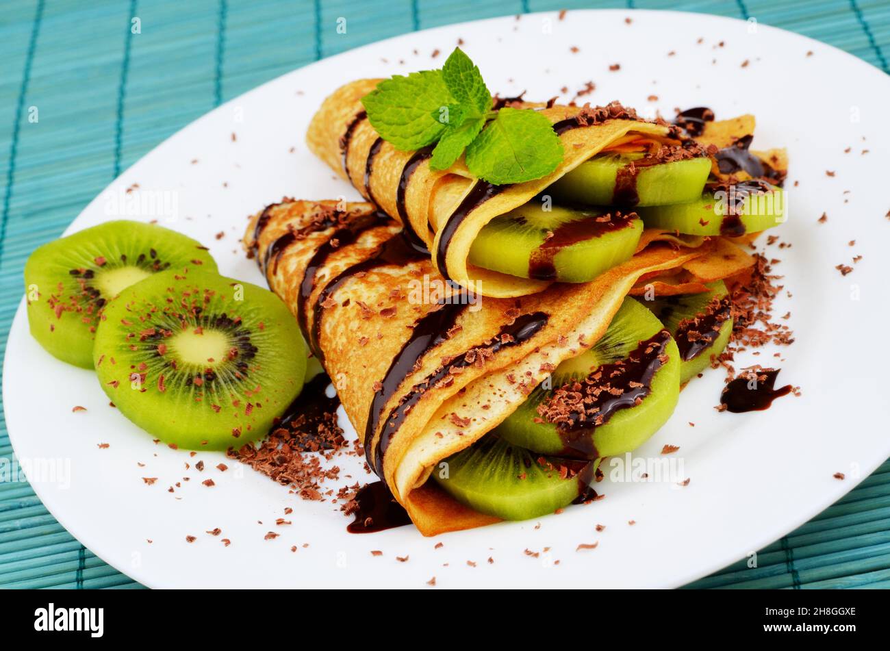 French style crepes with kiwi, chocolate sauce and chips Stock Photo ...