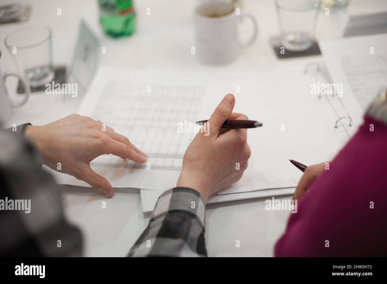 Close-up of hands with pen over paper during conference Stock Photo - Alamy