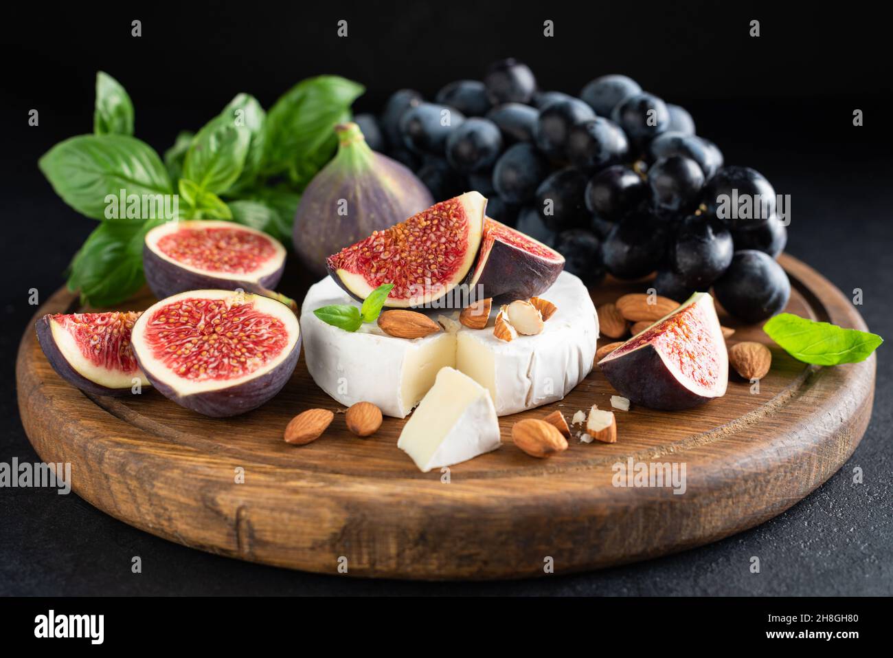 Camembert cheese platter with figs, grapes and nuts. Wooden cheese ...