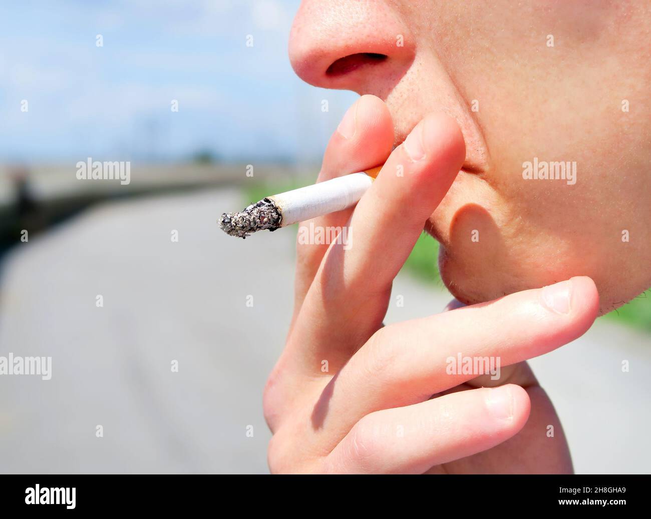 Young Man smoking a Cigarette outdoor closeup Stock Photo - Alamy