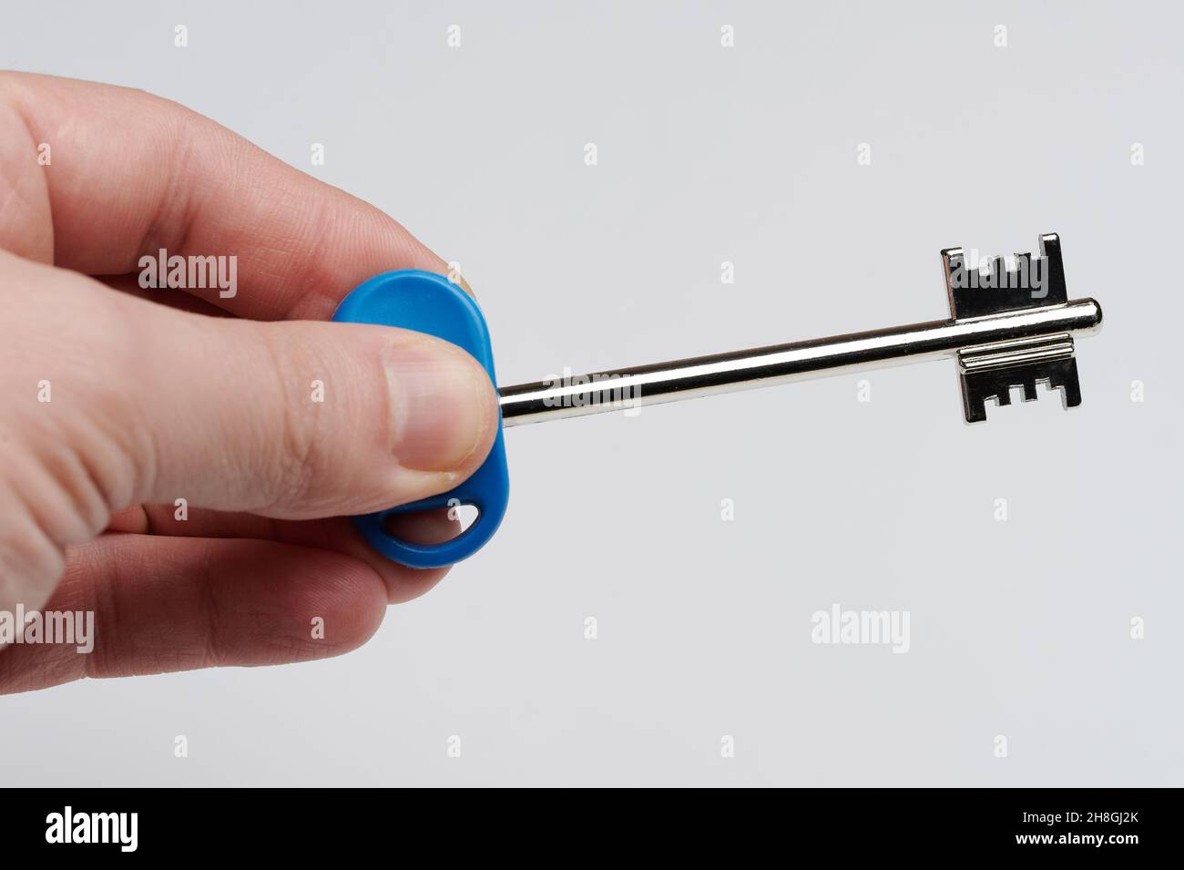 Long metal door key in hand close up view isolated Stock Photo - Alamy